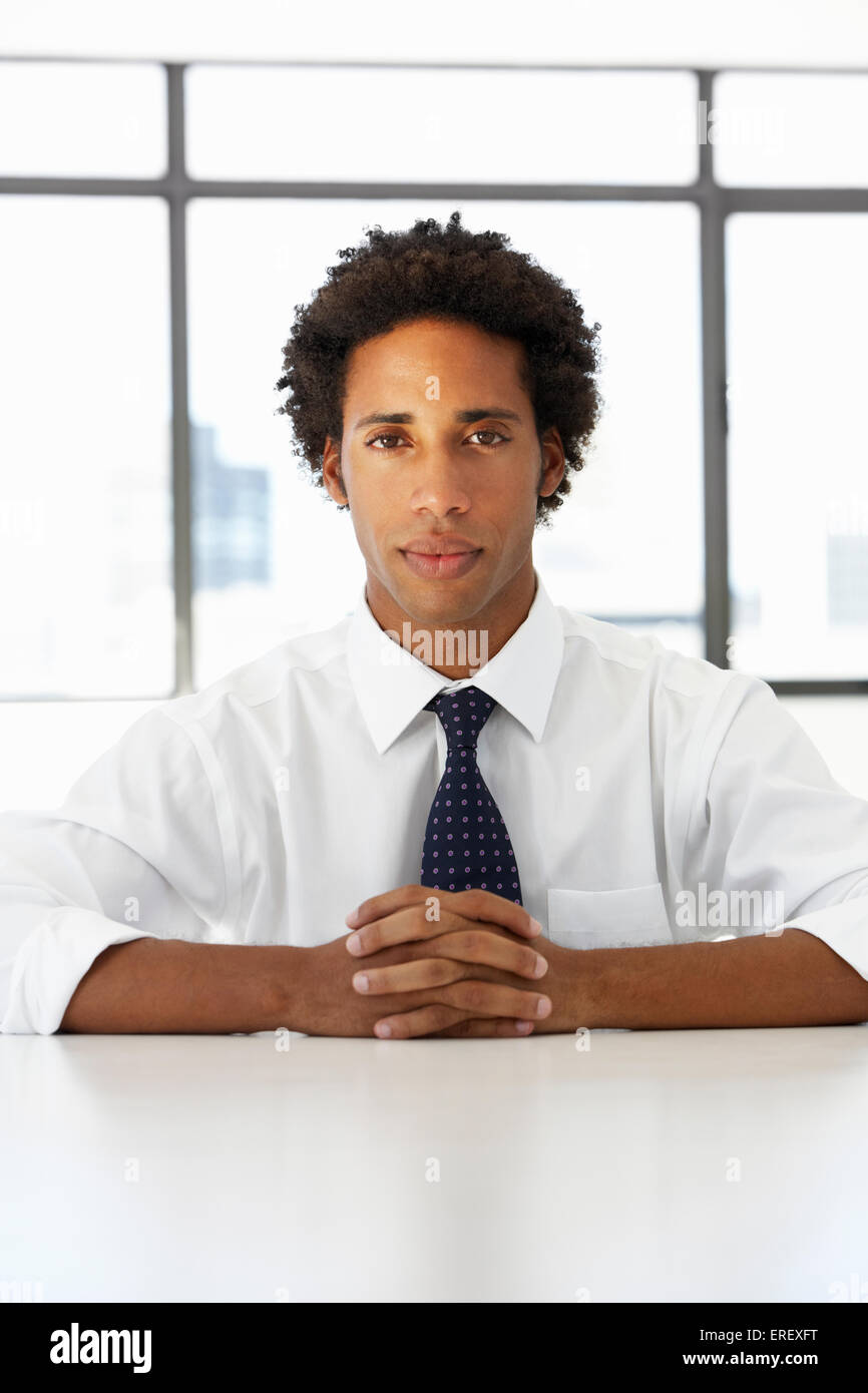 Businessman Sitting At Desk In Office Thinking Stock Photo - Alamy
