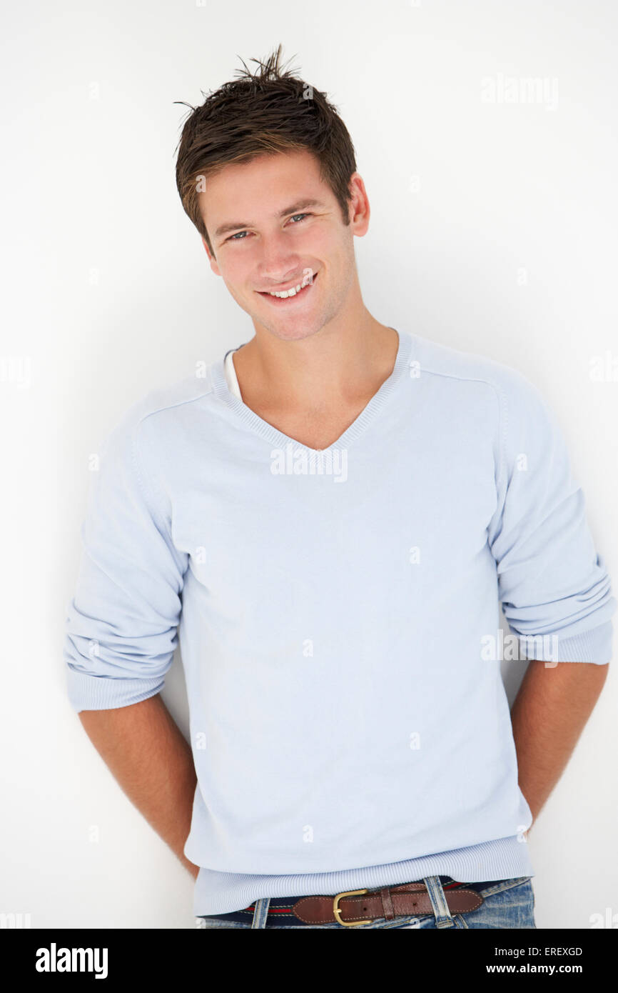 Studio Portrait Of Young Man Leaning Against White Background Stock ...