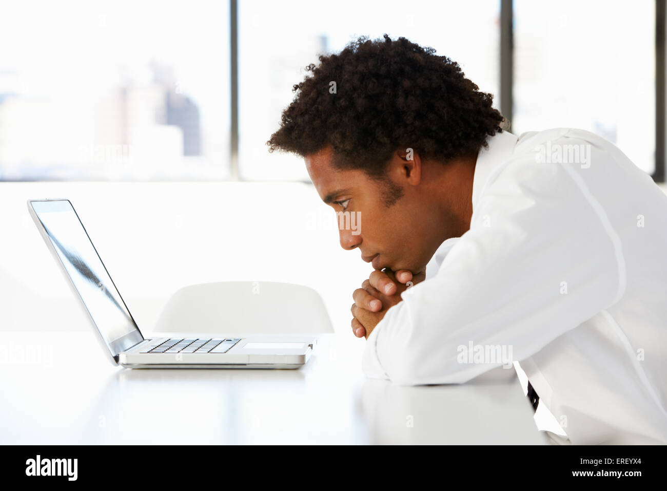 Businessman Sitting At Desk In Office Staring At Laptop Stock Photo - Alamy