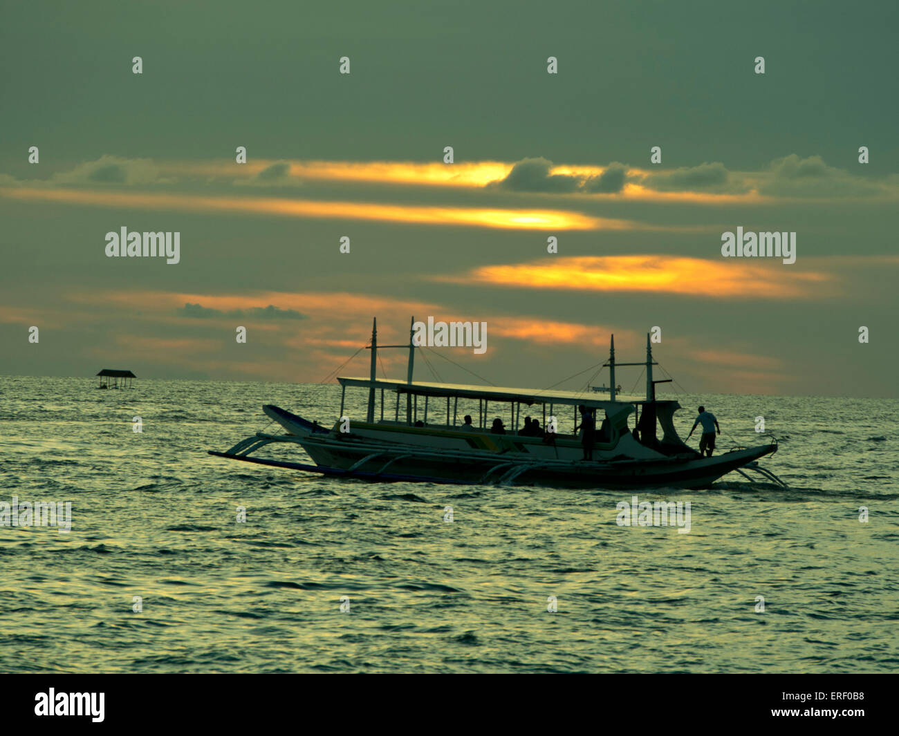 Tourists sailing on a traditional panga boat on a beach in Boracay ...