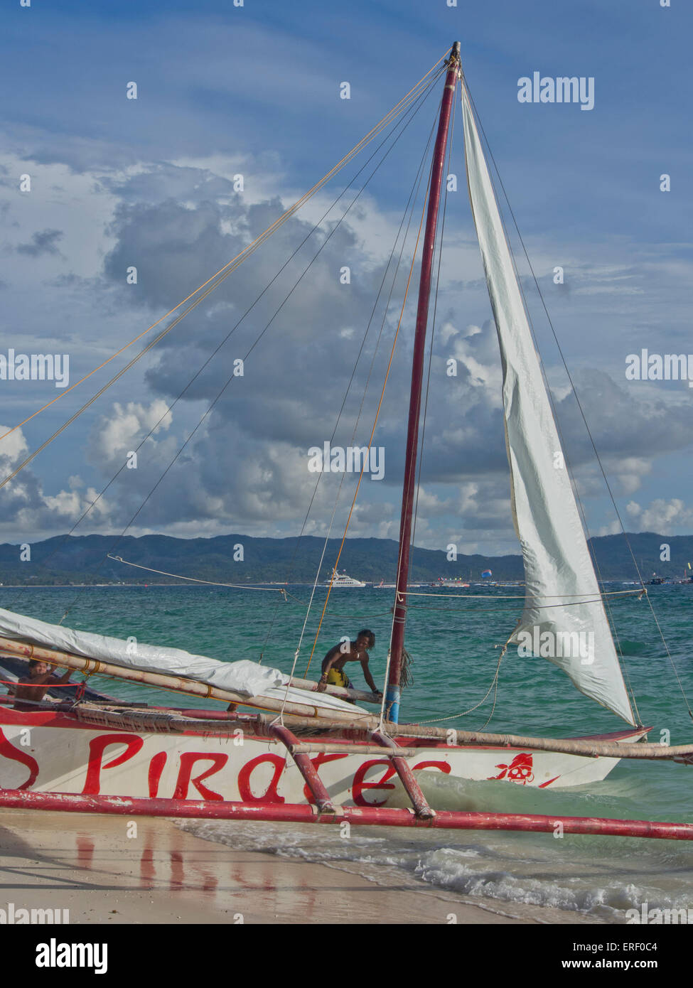 Tourists sailing on a traditional panga boat on a beach in Boracay ...