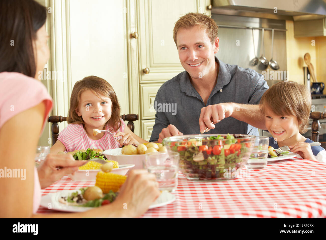 Family Eating Meal Together In Kitchen Stock Photo - Alamy