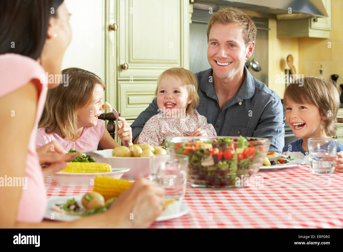 Family Eating Meal Together In Kitchen Stock Photo - Alamy