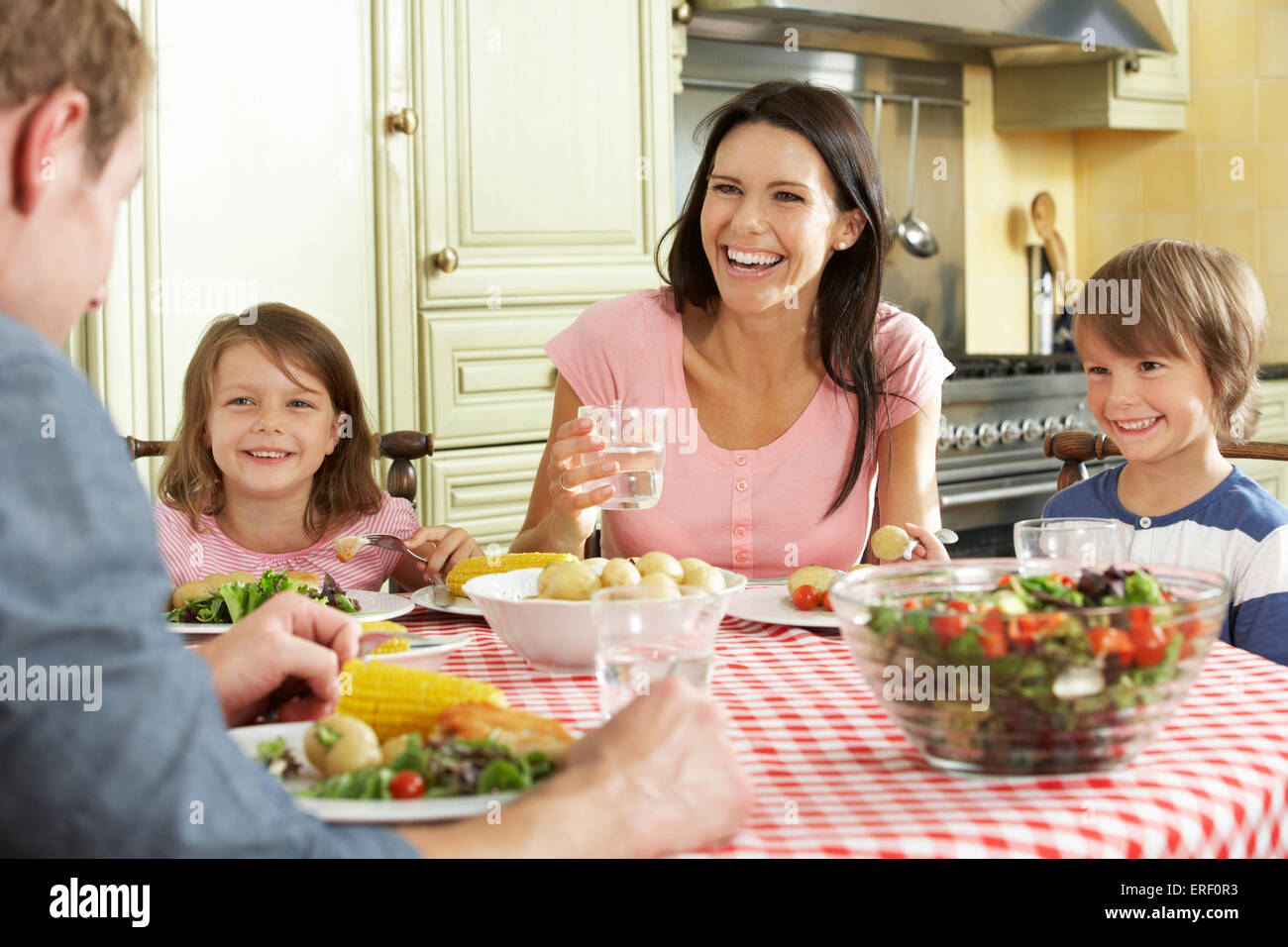 Family Eating Meal Together In Kitchen Stock Photo - Alamy
