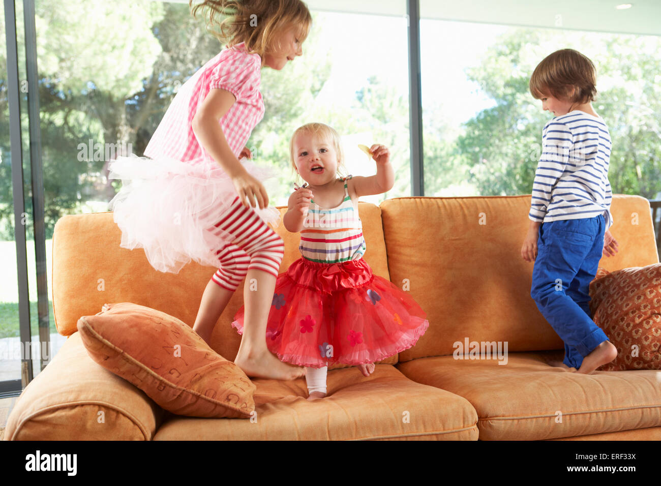 Group Of Children Jumping On Sofa Stock Photo - Alamy