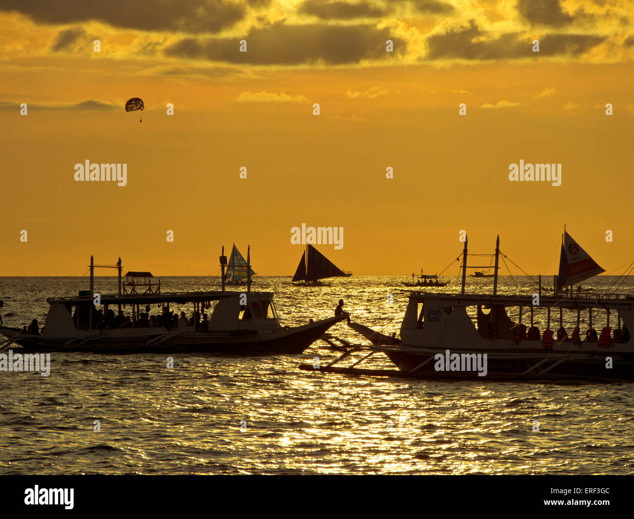 Tourists boarding a traditional panga boat in Boracay, Philippines ...