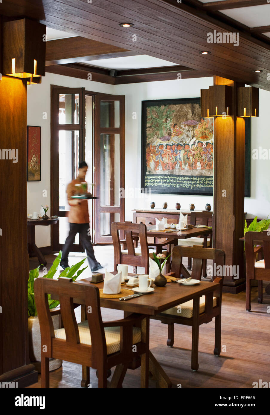 Young Asian server sets up tables in The Dining Room at La Residence d ...