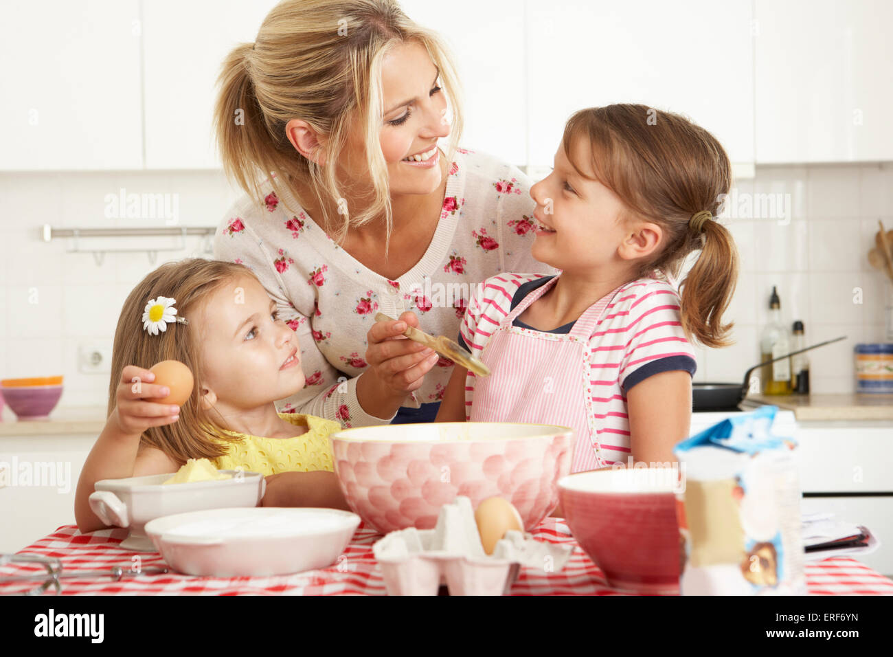 Mother And Two Girls Baking In Kitchen Stock Photo - Alamy