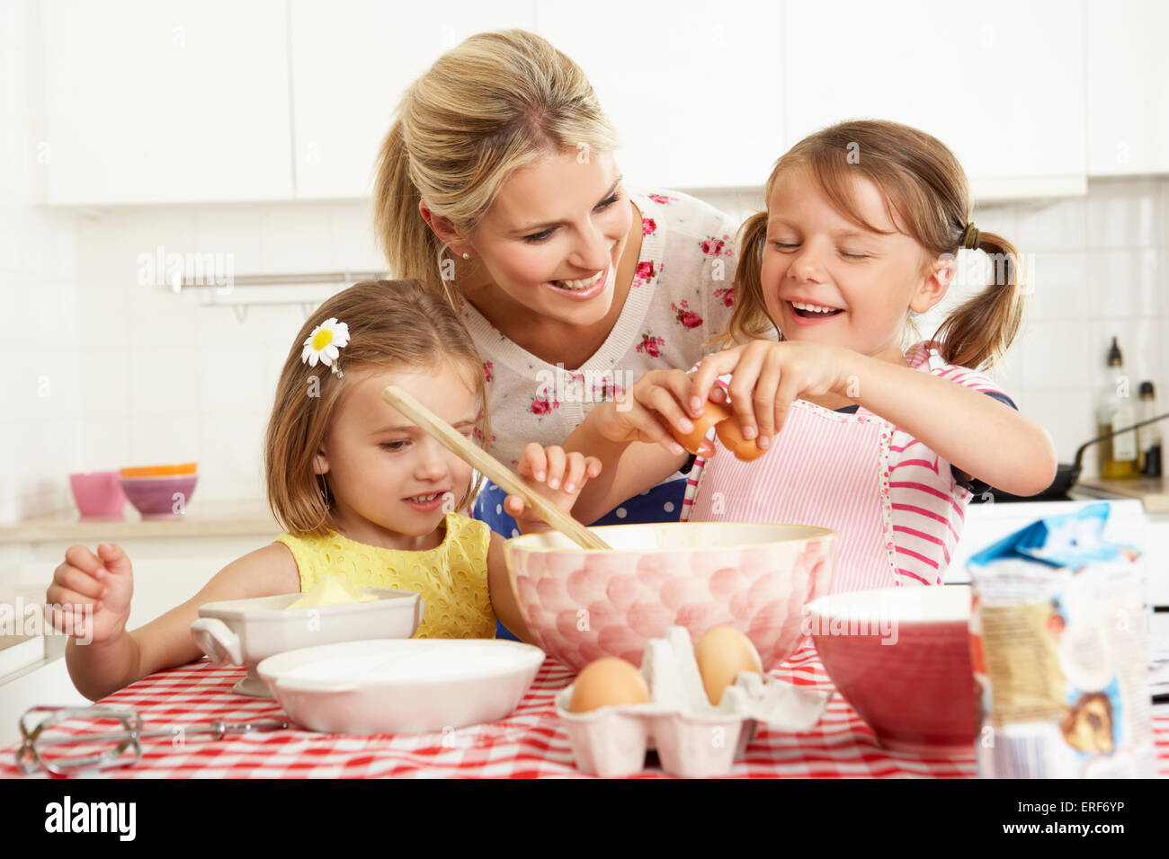 Mother And Two Girls Baking In Kitchen Stock Photo - Alamy
