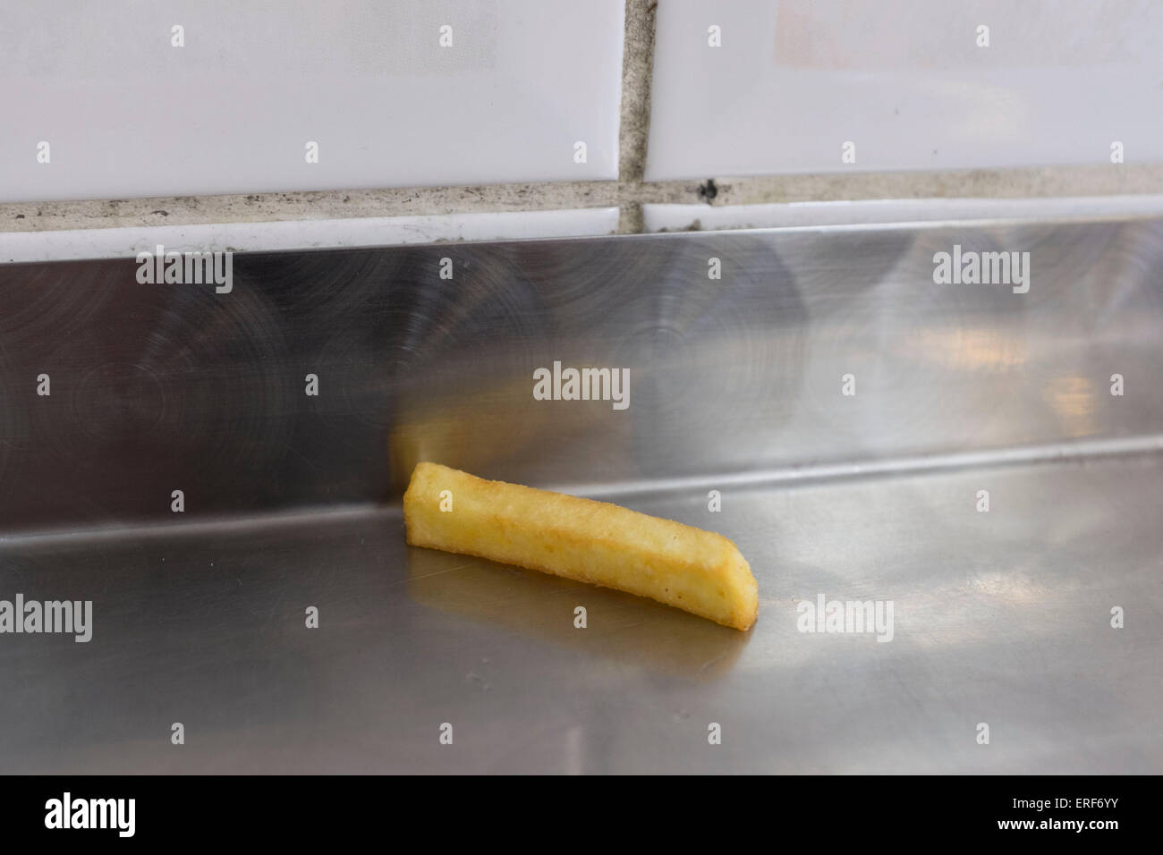 Fried chip on a fast food stainless steel counter top. London, UK. Also ...