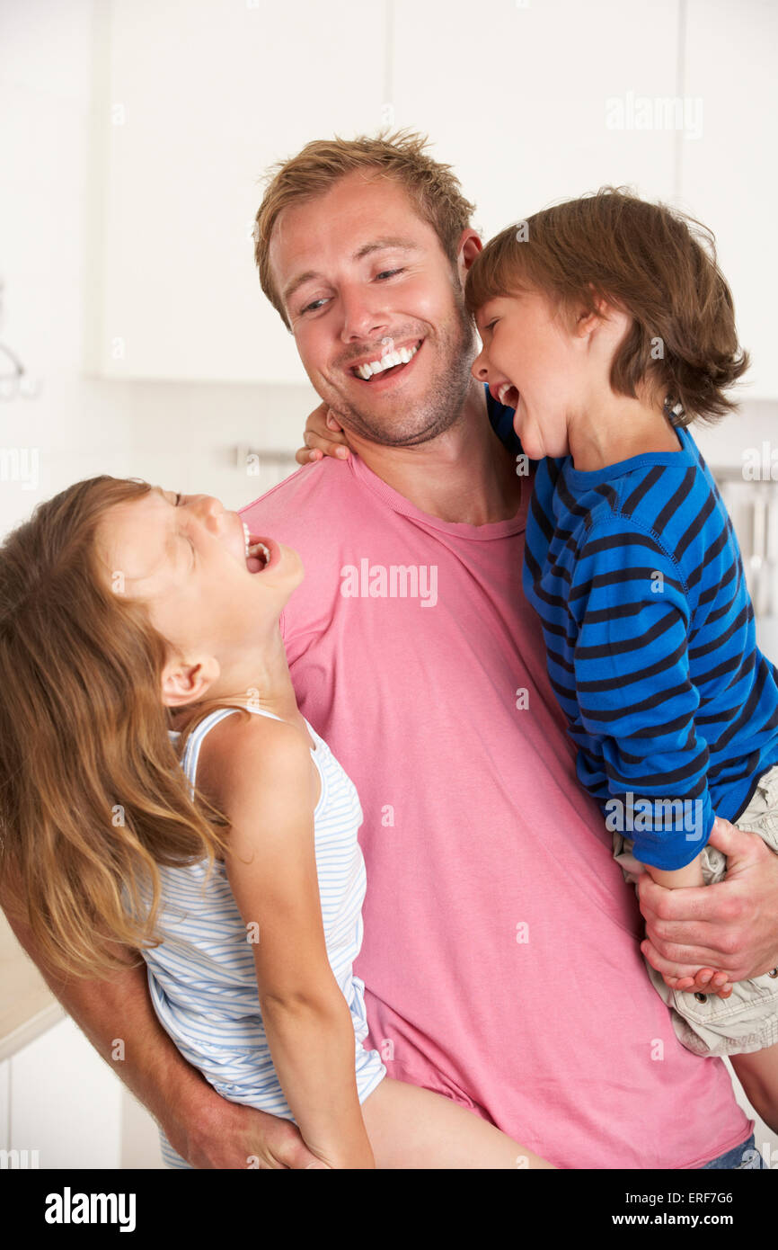 Father Giving Children Cuddle At Home Stock Photo - Alamy