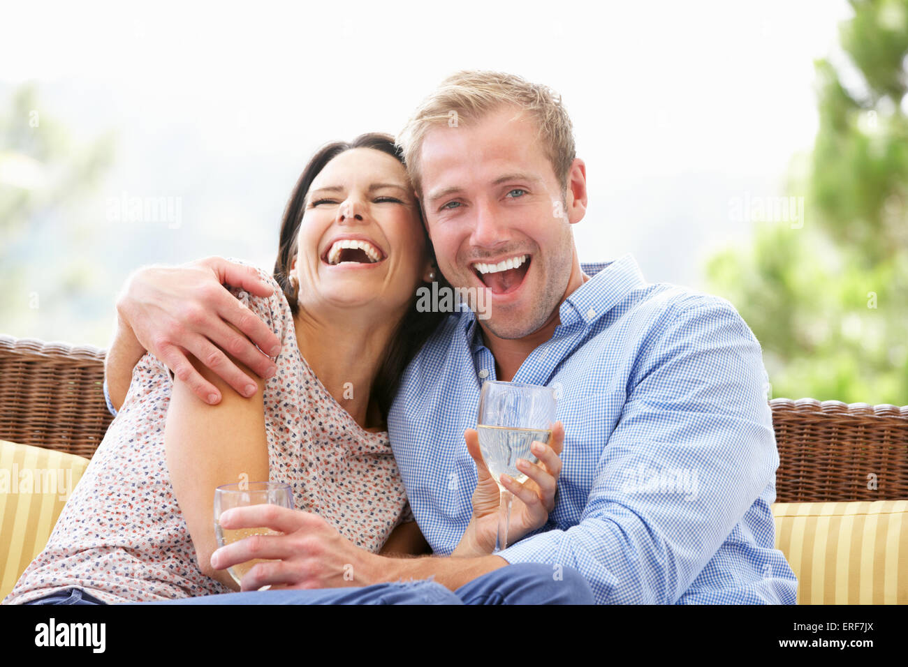 Couple Sitting On Outdoor Seat Together Stock Photo - Alamy