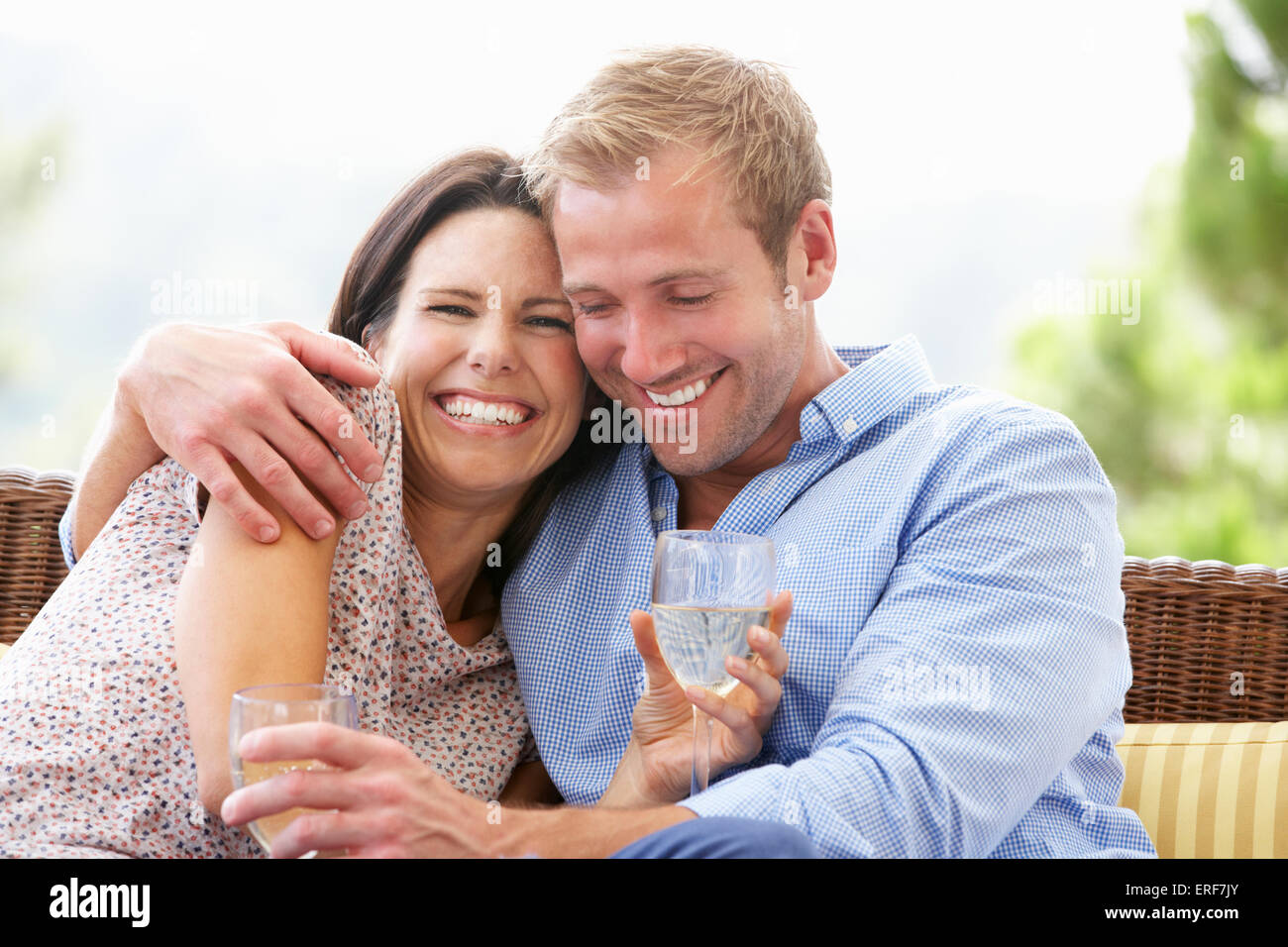 Couple Sitting On Outdoor Seat Together Stock Photo - Alamy