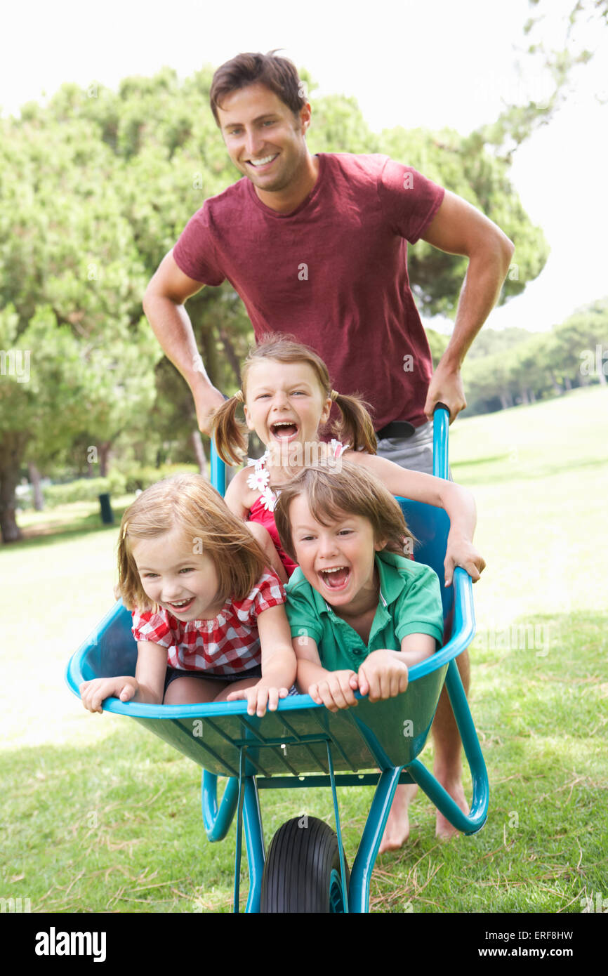 Father Giving Children Ride In Wheelbarrow Stock Photo - Alamy
