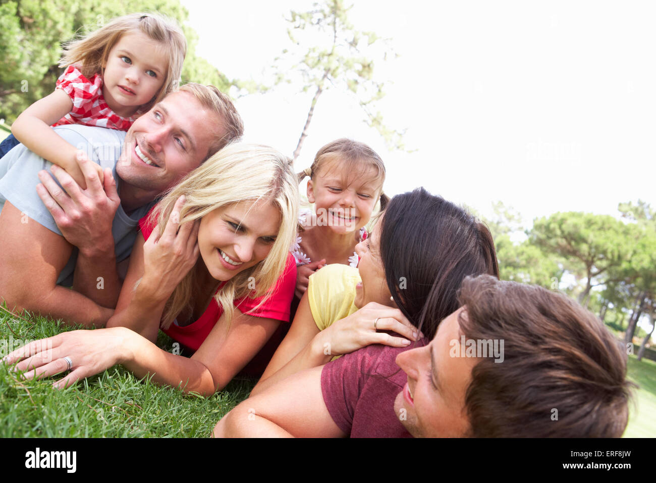 Two Families Playing In Park Together Stock Photo - Alamy