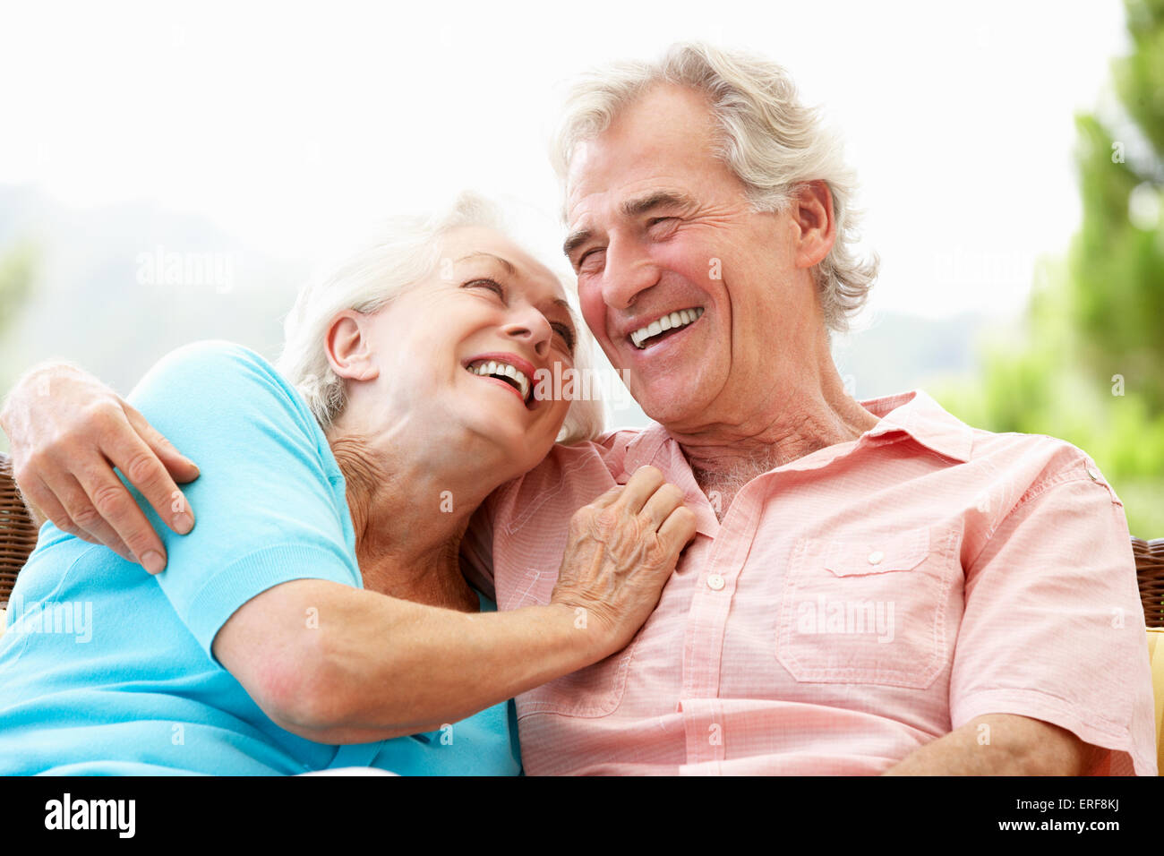 Senior Couple Sitting On Outdoor Seat Together Stock Photo - Alamy