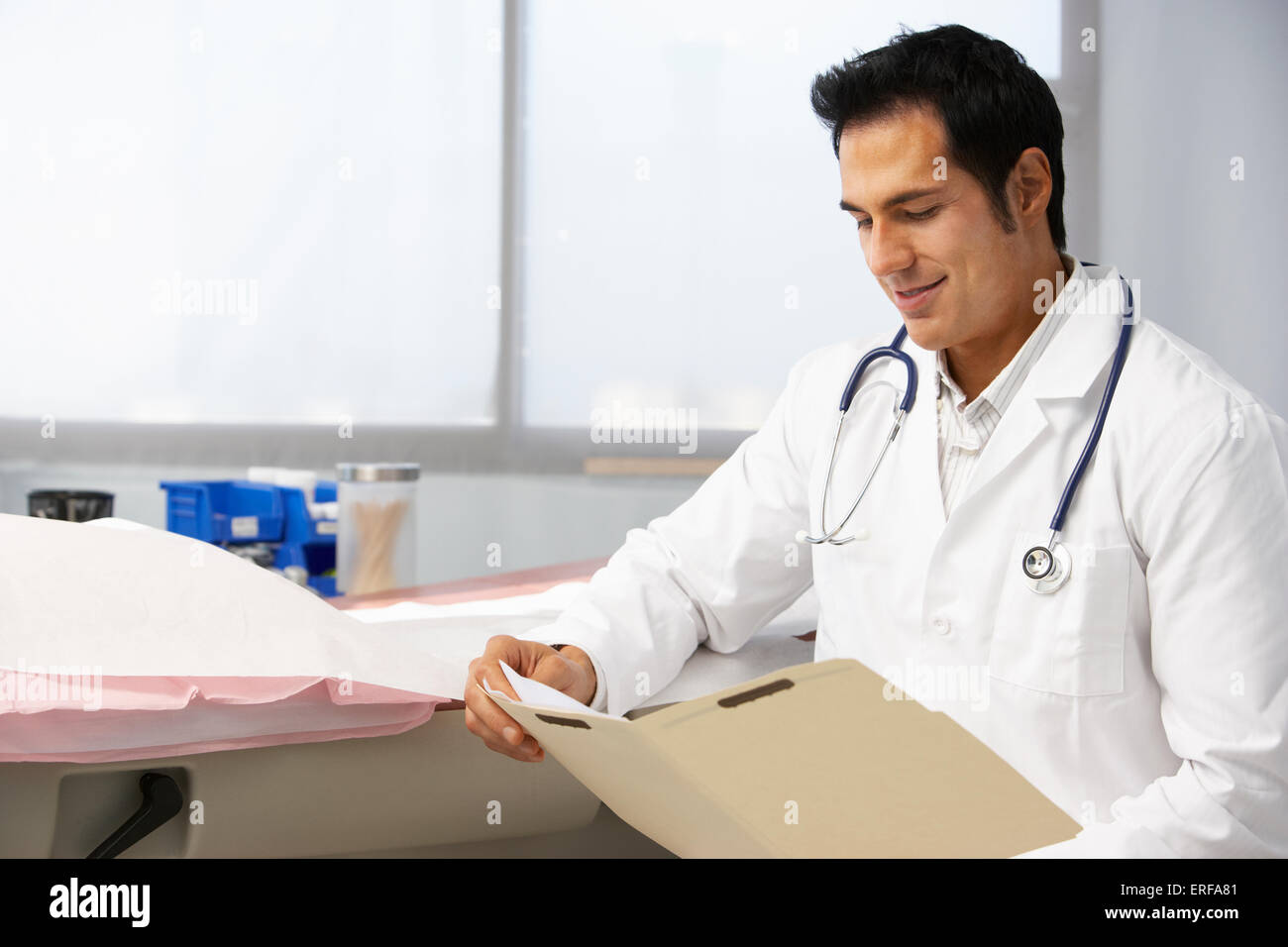 Male Doctor In Surgery Reading Patient Notes Stock Photo - Alamy