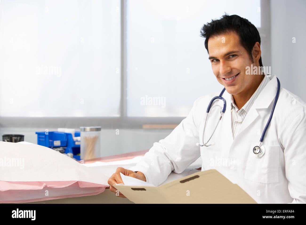 Male Doctor In Surgery Reading Patient Notes Stock Photo - Alamy