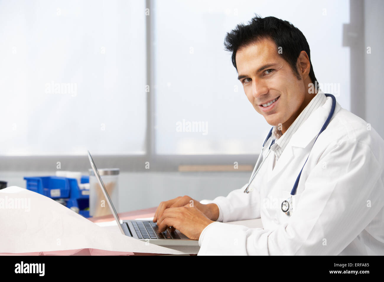 Male Doctor In Surgery Using Laptop Stock Photo - Alamy