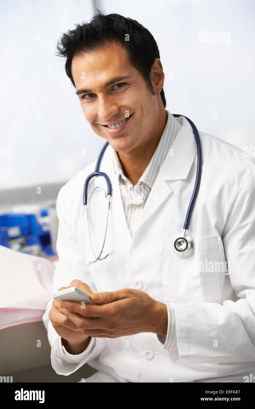 Male Doctor In Surgery Using Mobile Phone Stock Photo - Alamy