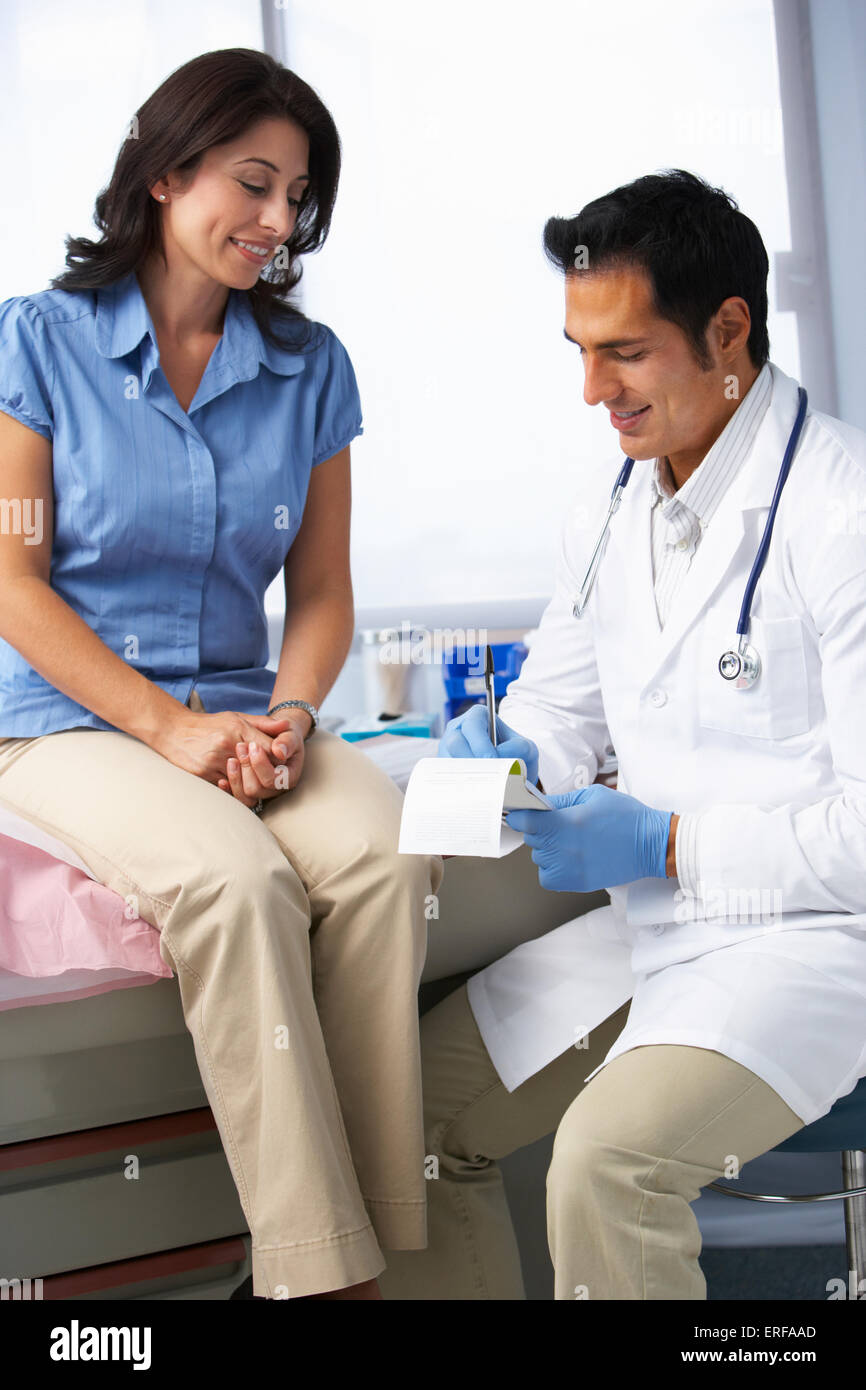 Doctor In Surgery With Female Patient Writing Prescription Stock Photo ...
