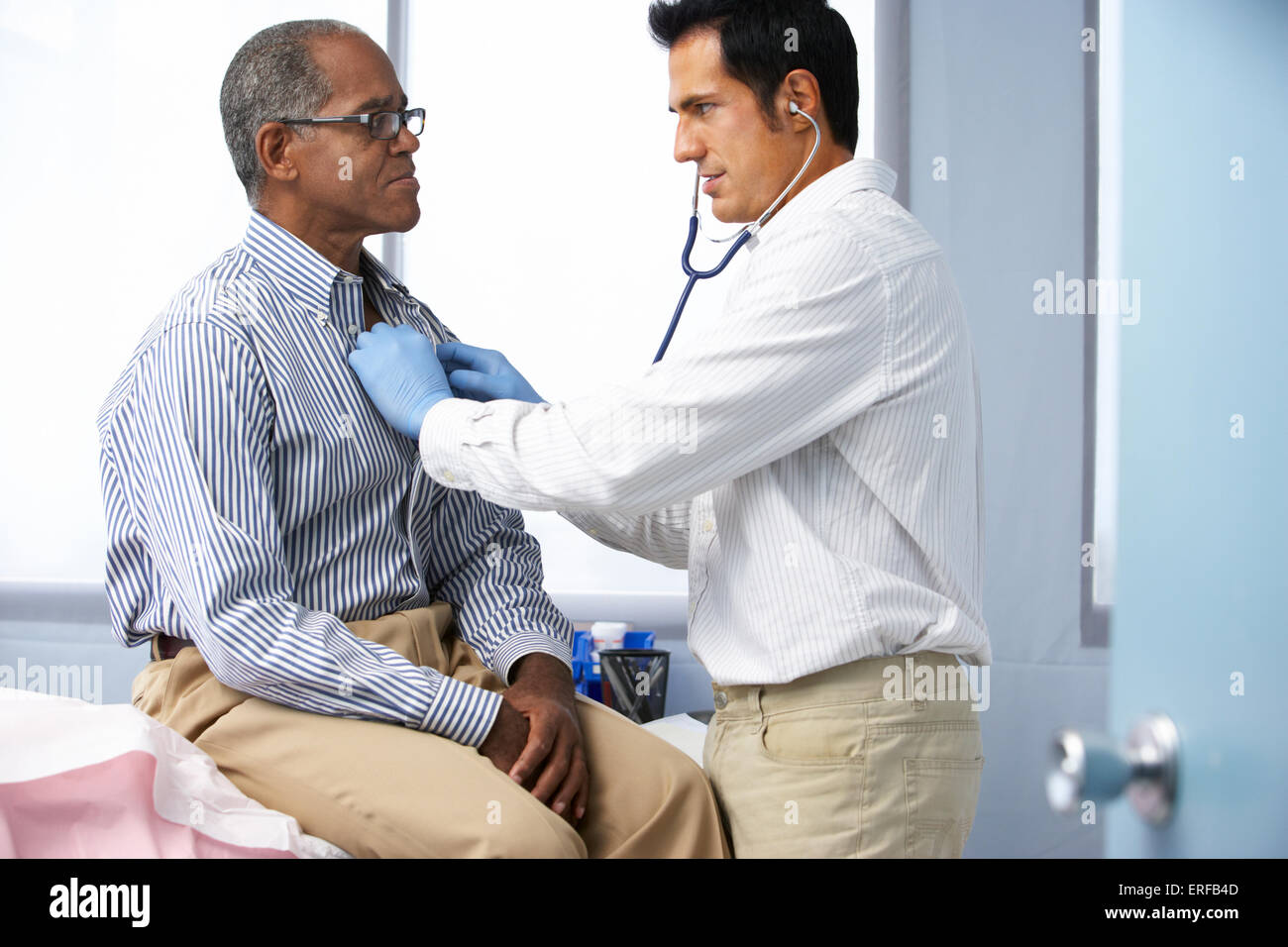Doctor In Surgery Listening To Male Patient's Chest Stock Photo - Alamy