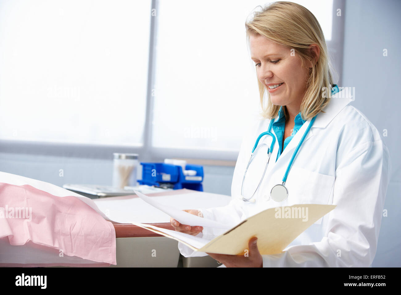 Female Doctor In Surgery Reading Patient Notes Stock Photo - Alamy