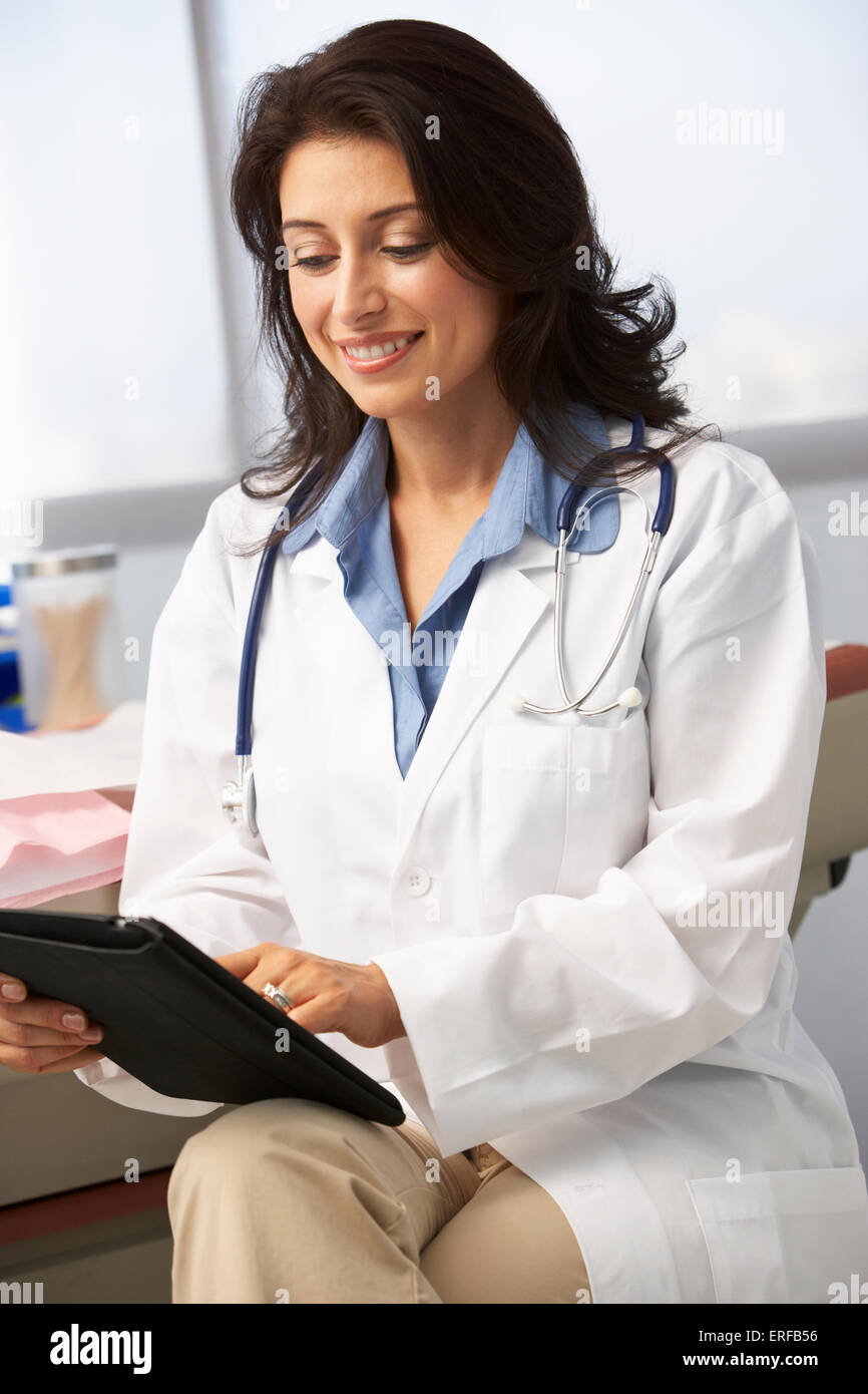 Female Doctor In Surgery Reading Patient Notes Stock Photo - Alamy