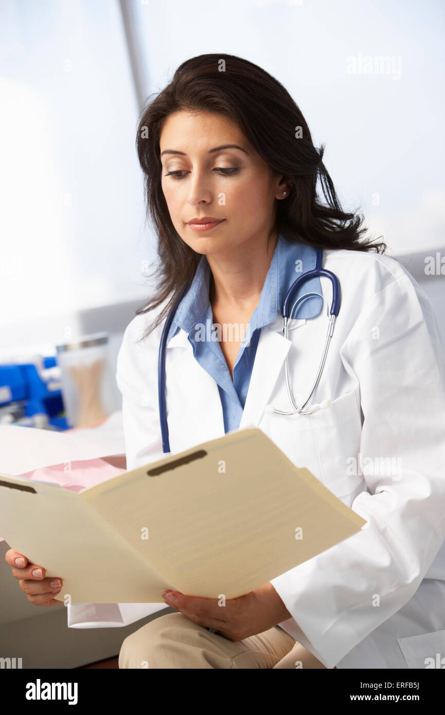 Female Doctor In Surgery Reading Patient Notes Stock Photo - Alamy
