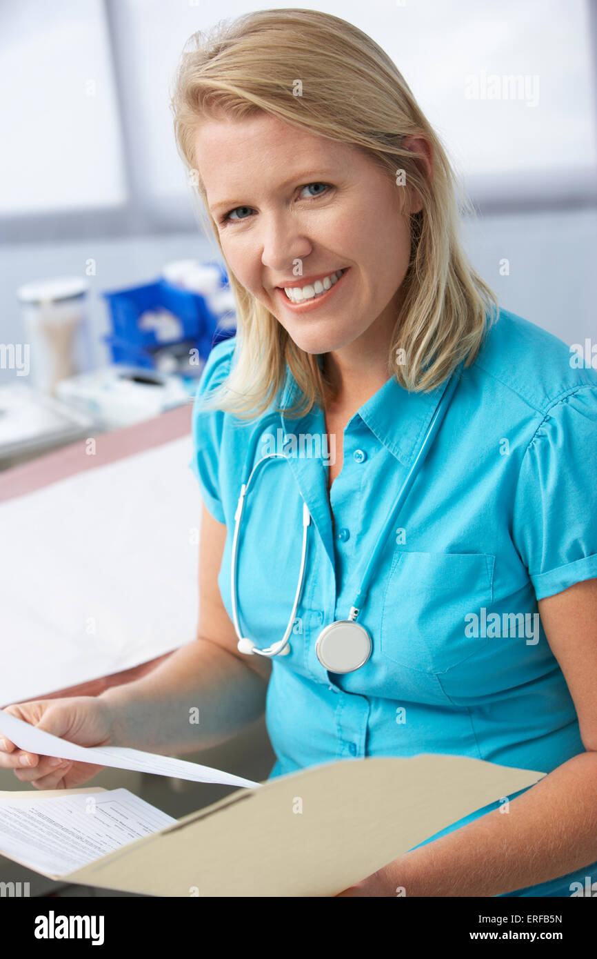 Female Doctor In Surgery Reading Patient Notes Stock Photo - Alamy