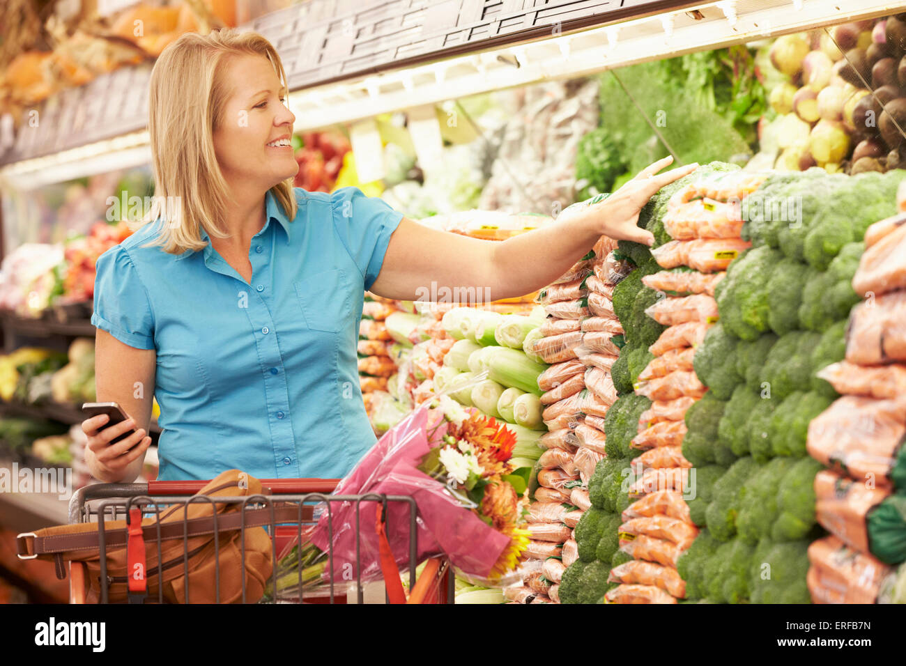Woman Holding Mobile Phone In Supermarket Stock Photo - Alamy