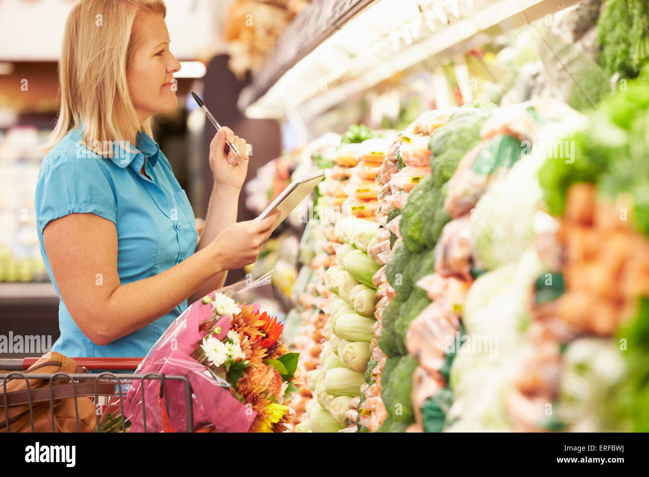 Woman Reading Shopping List In Supermarket Stock Photo - Alamy