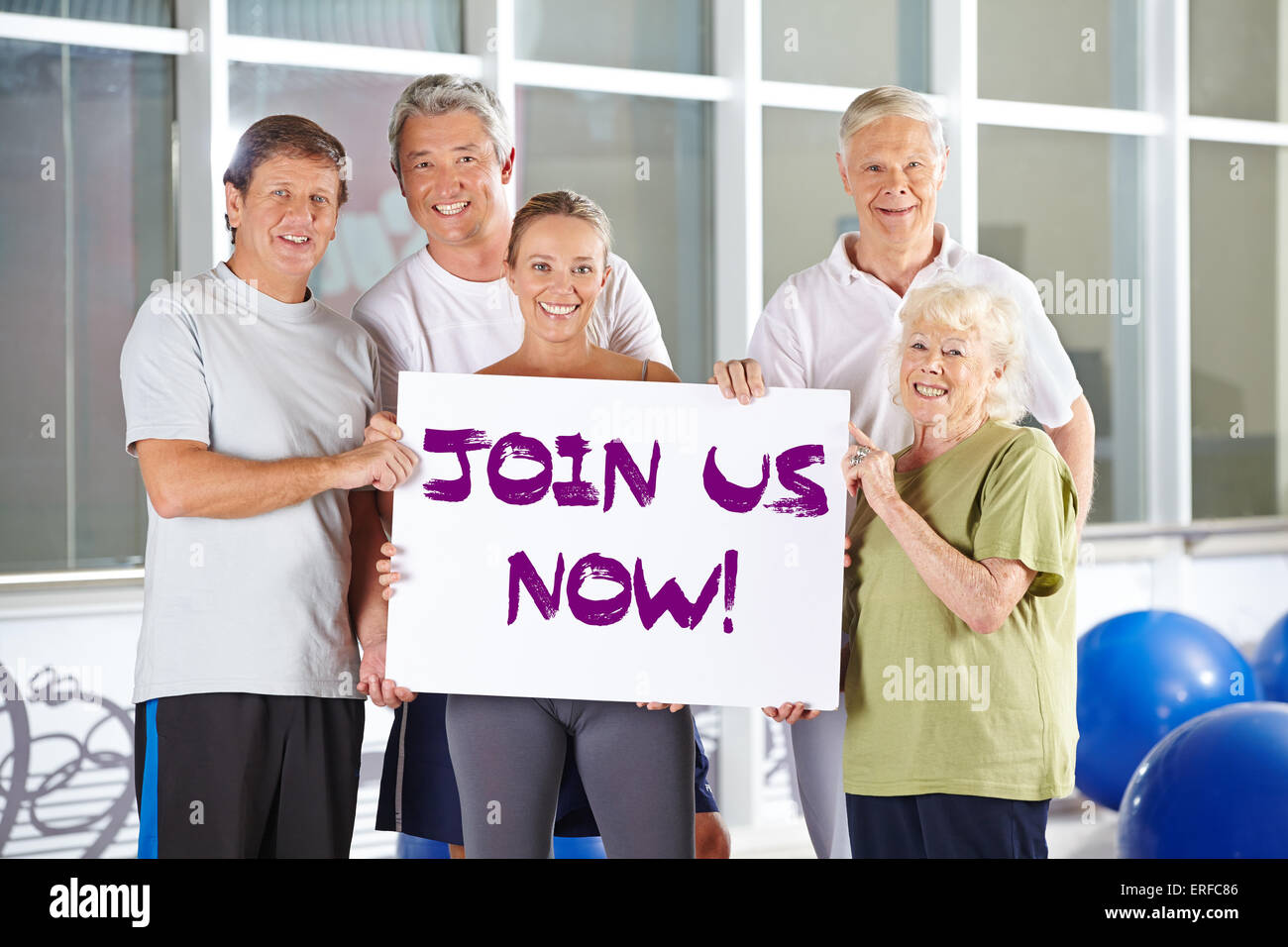 Group of senior poeple holding a "Join us now" sign in a gym Stock ...