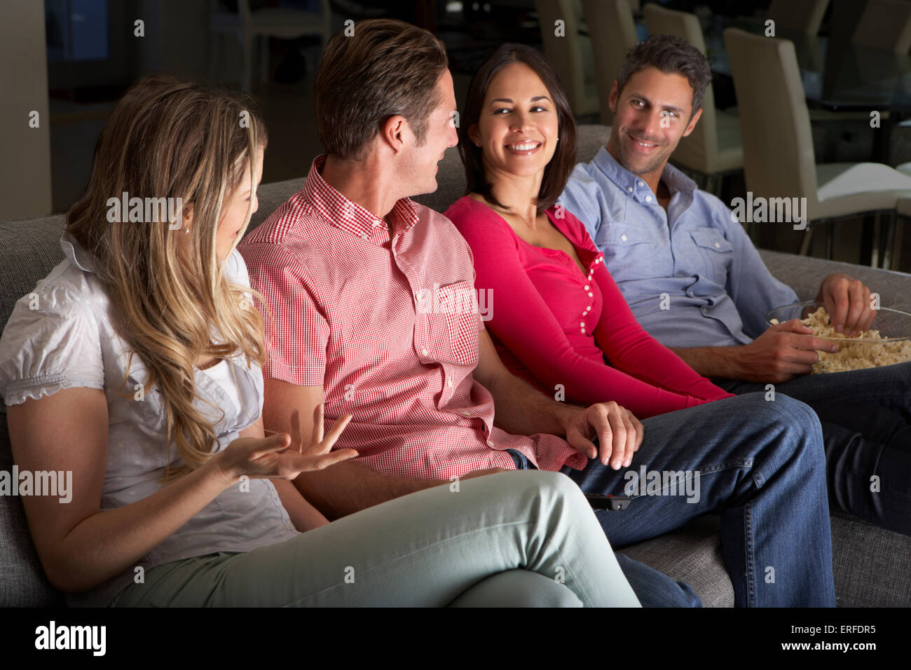 Group Of Friends Sitting On Sofa Watching TV Together Stock Photo - Alamy