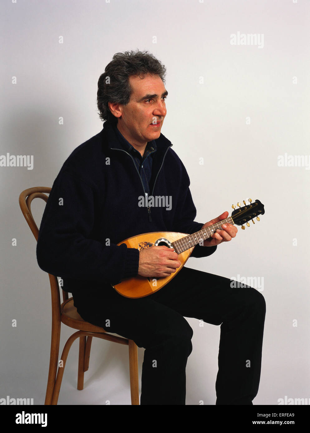 Mandolin being played by a seated man. Sitting. White background Stock ...