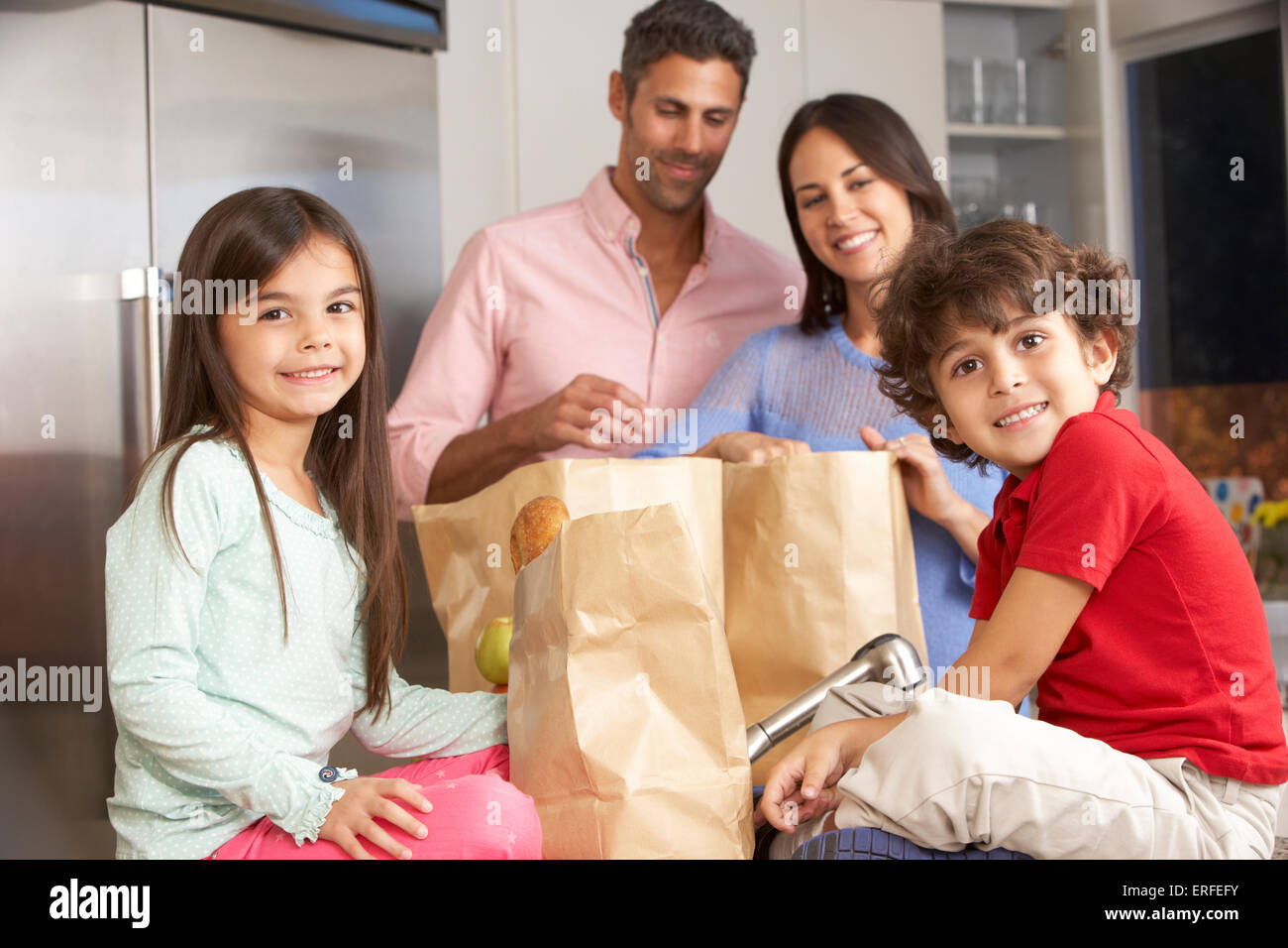 Family Unpacking Grocery Shopping In Kitchen Stock Photo - Alamy