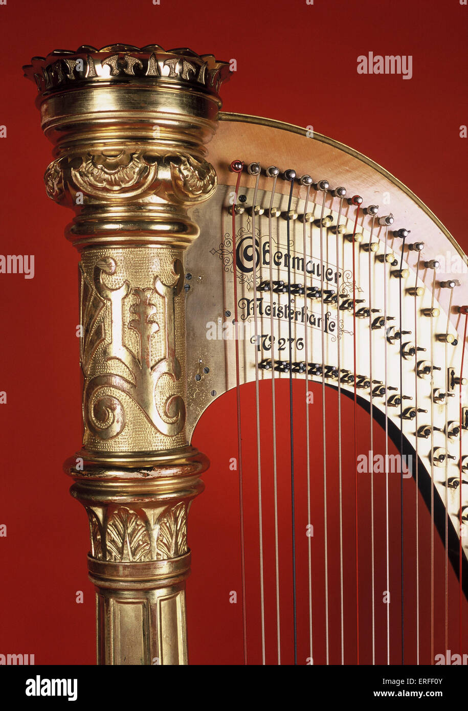 Close-up of a harp's tuning pins and top of column. Red background ...