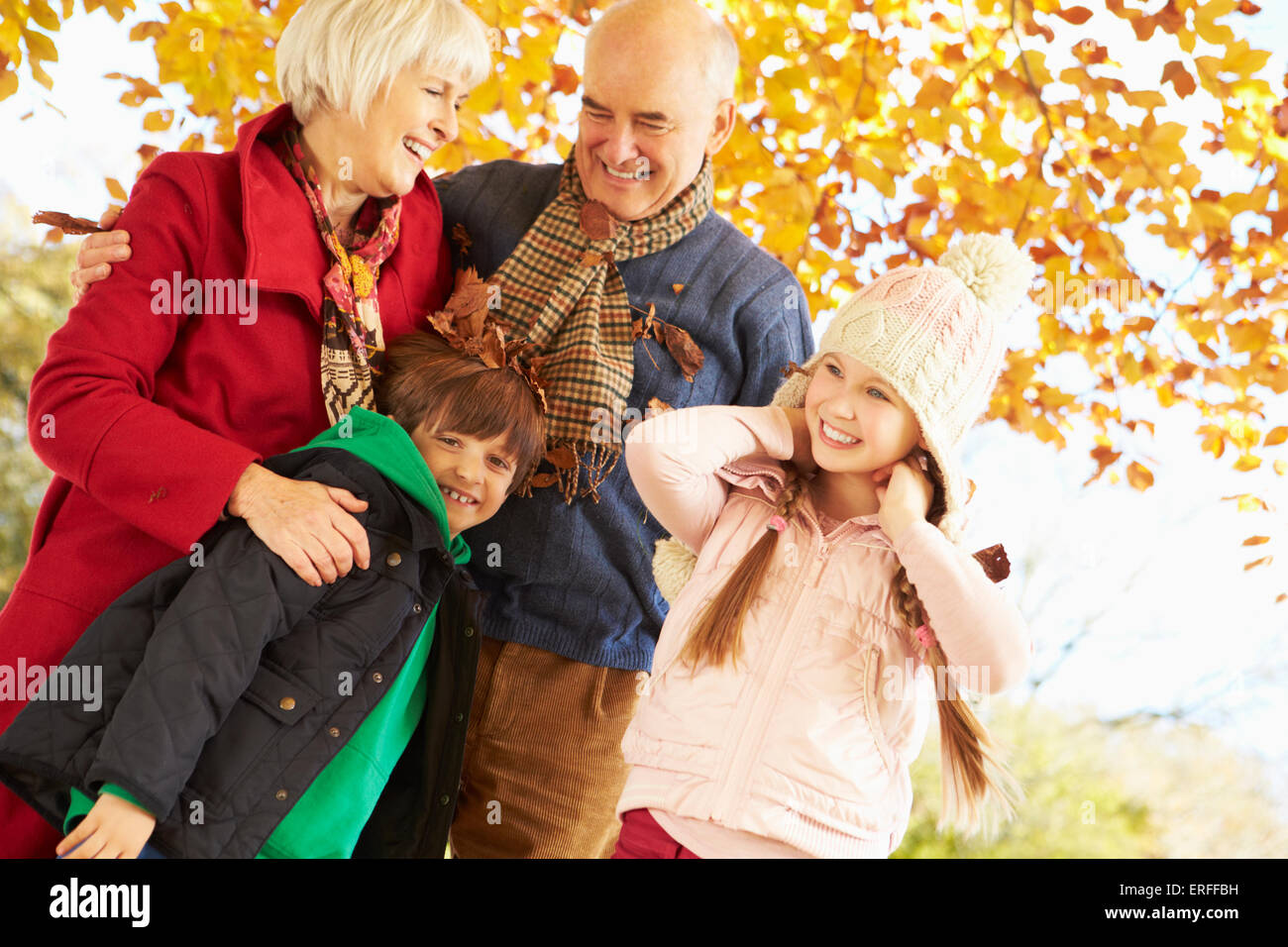 Grandparents And Grandchildren Playing Under Autumn Tree Stock Photo ...