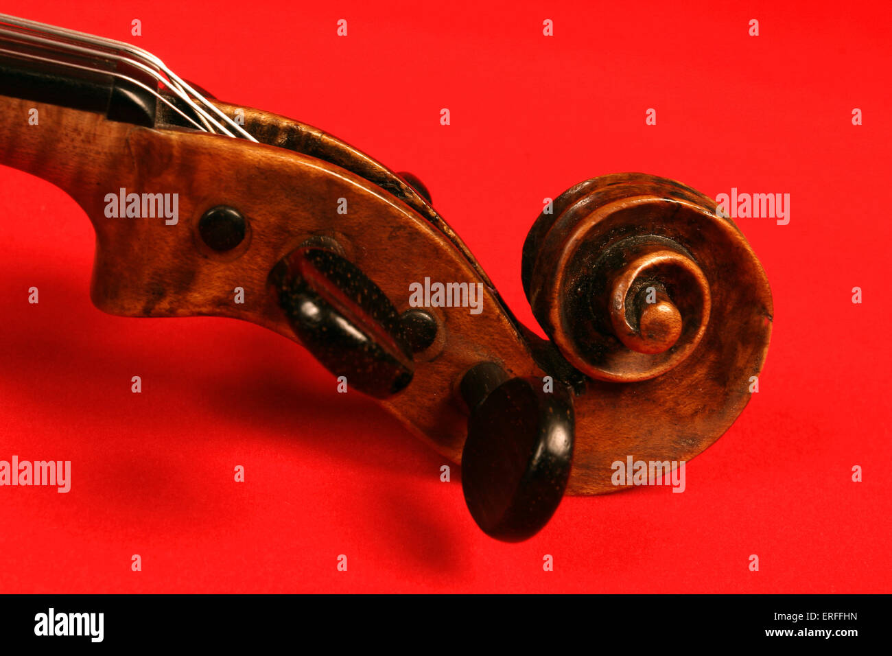 Violin scroll, 19th century English violin red background Stock Photo ...