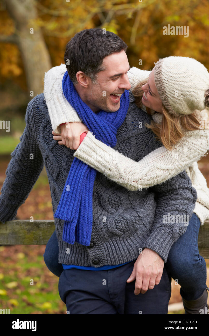 Romantic Couple Sitting On Fence In Autumn Woodland Stock Photo - Alamy
