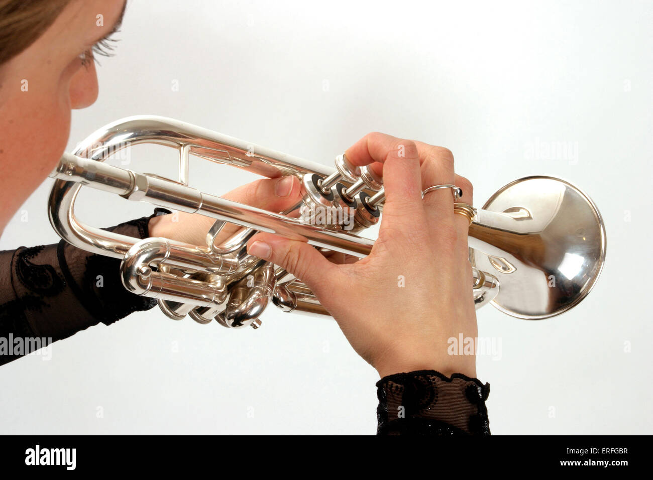 B flat trumpet being held in playing position. Close-up of fingers and ...