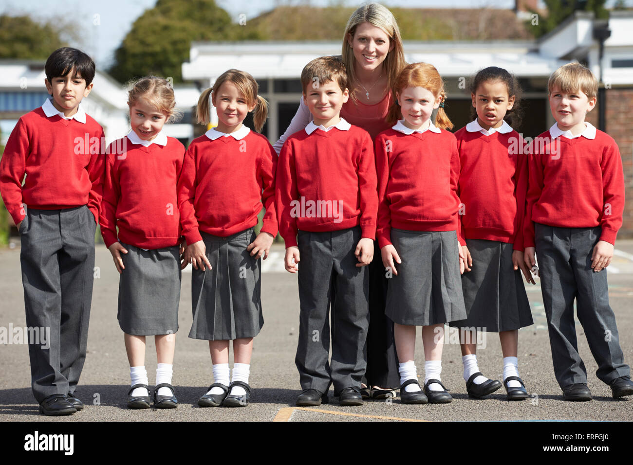 Elementary School Pupils With Teacher In Playground Stock Photo - Alamy