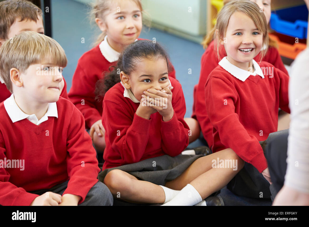 Pupils Sitting On Mat Listening To Teacher Stock Photo - Alamy