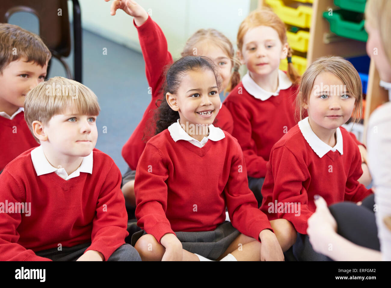 Pupils Sitting On Mat Listening To Teacher Stock Photo - Alamy