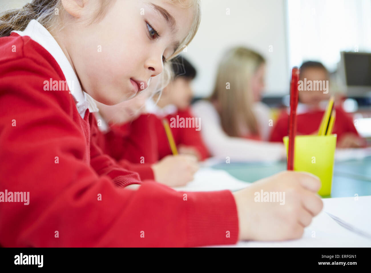 Female Elementary Pupil Working At Desk Stock Photo - Alamy