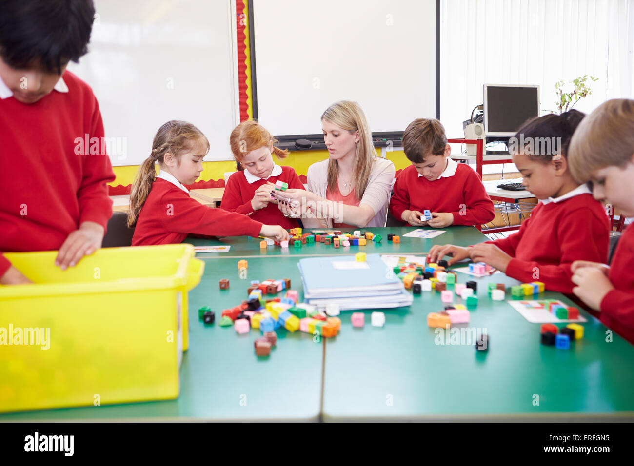 Pupils And Teacher Working With Coloured Blocks Stock Photo - Alamy