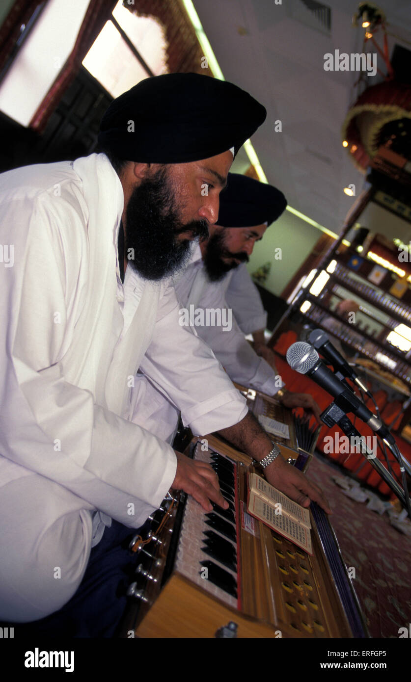 Sikh musicians playing to the congregation of a Sikh temple or Gurdwara ...