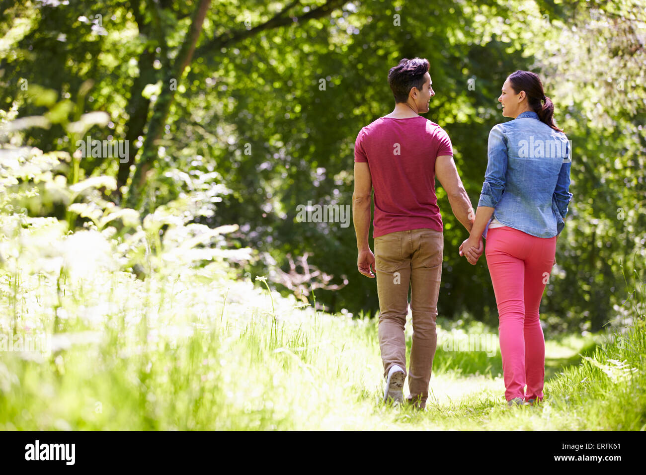 Rear View Of Young Couple Walking In Summer Countryside Stock Photo - Alamy
