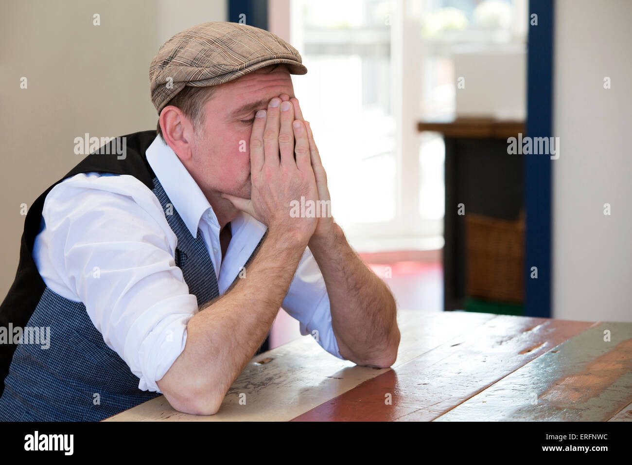 man in his 50's sitting at table and looks tired Stock Photo - Alamy