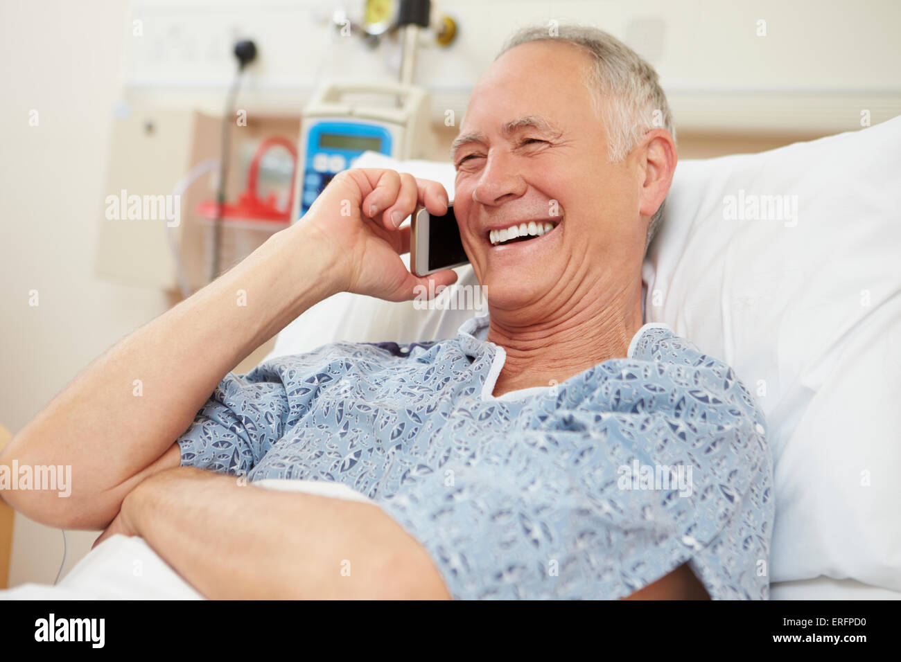 Senior Male Patient Using Mobile Phone In Hospital Bed Stock Photo - Alamy
